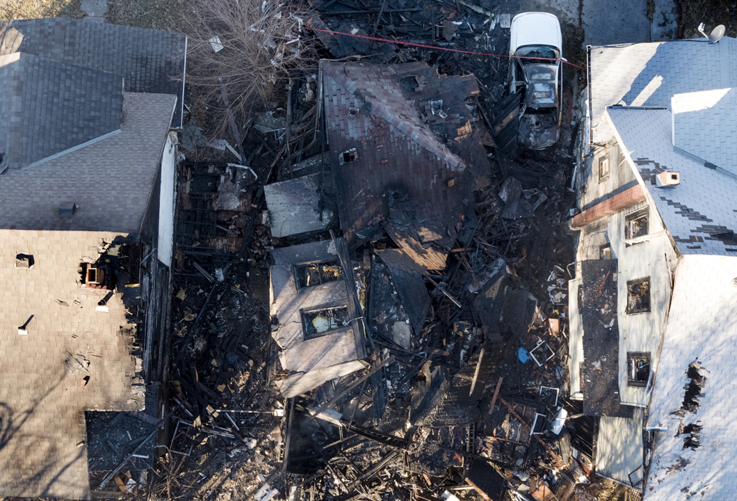 Explosion levels house and damages two more as firefighters battle ...
