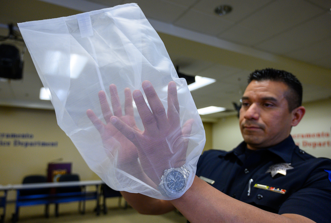 Sacramento police officer demonstrates a spit mask used on suspects ...