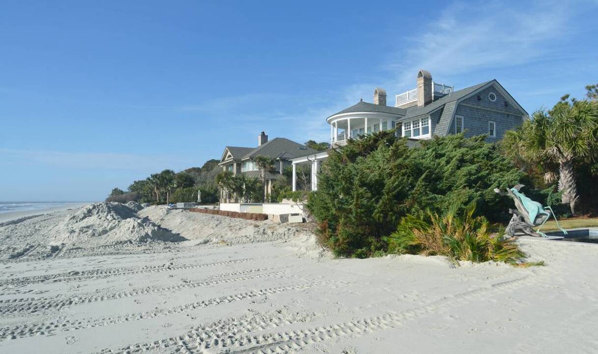 A temporary sand berm is all that protects these homes from the ocean ...